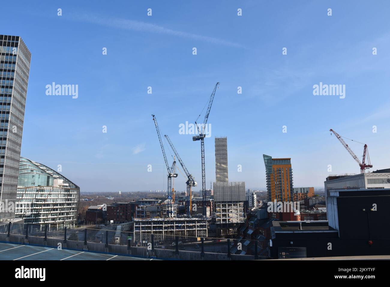 A scenery of urban buildings and new constructions with cranes in ...