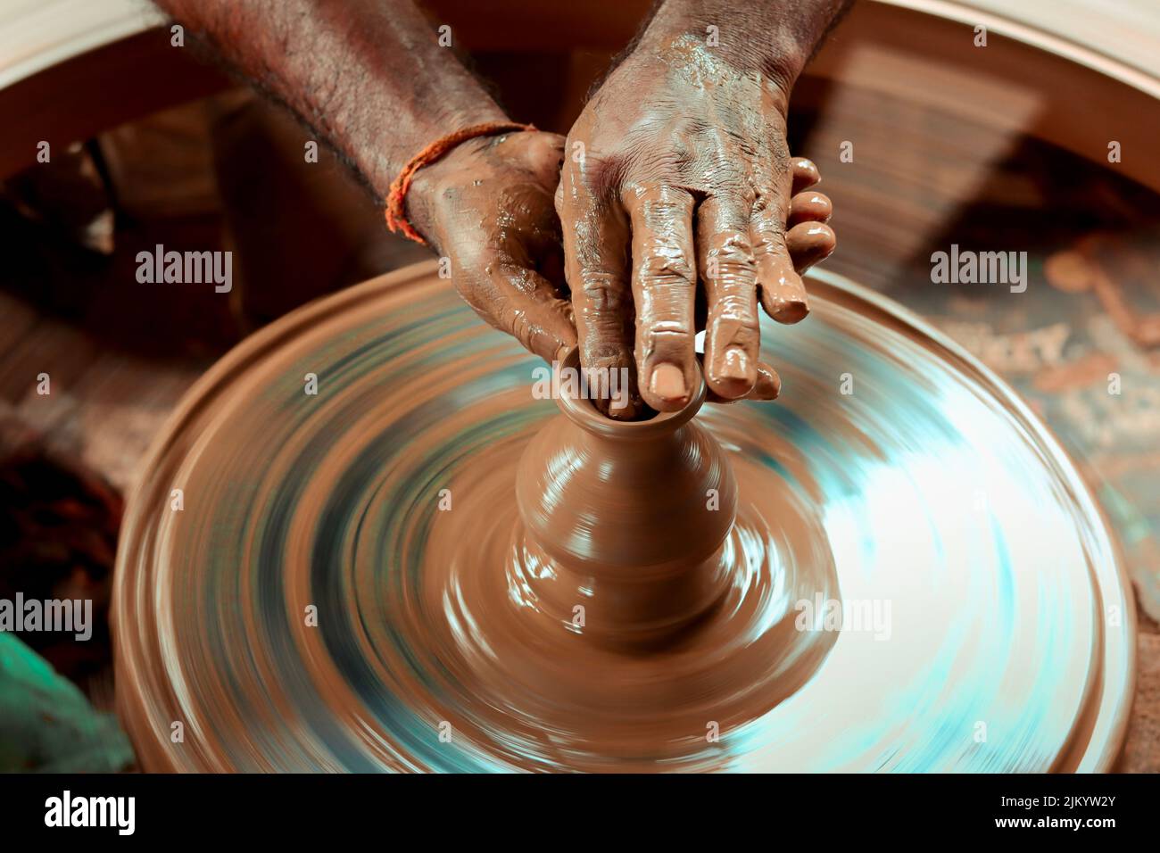 A slow shutter speed shot of a potter hand making a pot from a pottery ...