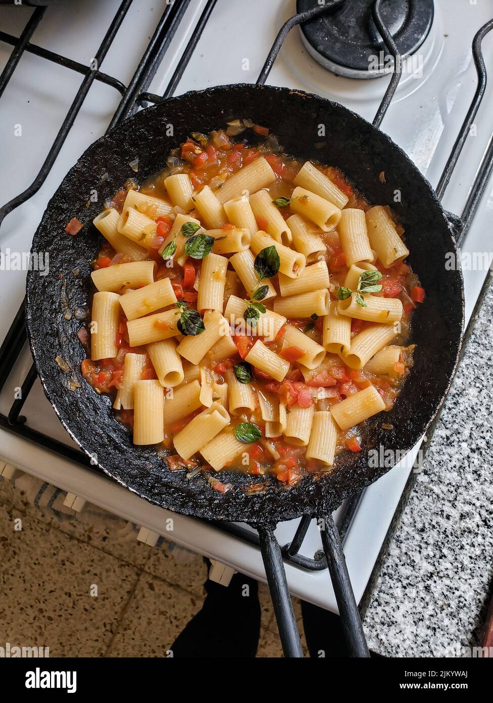 A top view of pasta with a tomato sauce with vegetables in a pan on a ...