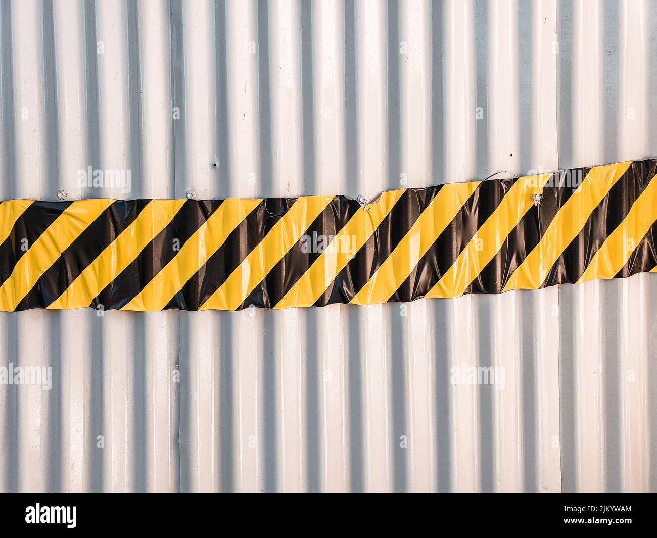 A closeup of a black and yellow barrier tape Stock Photo - Alamy