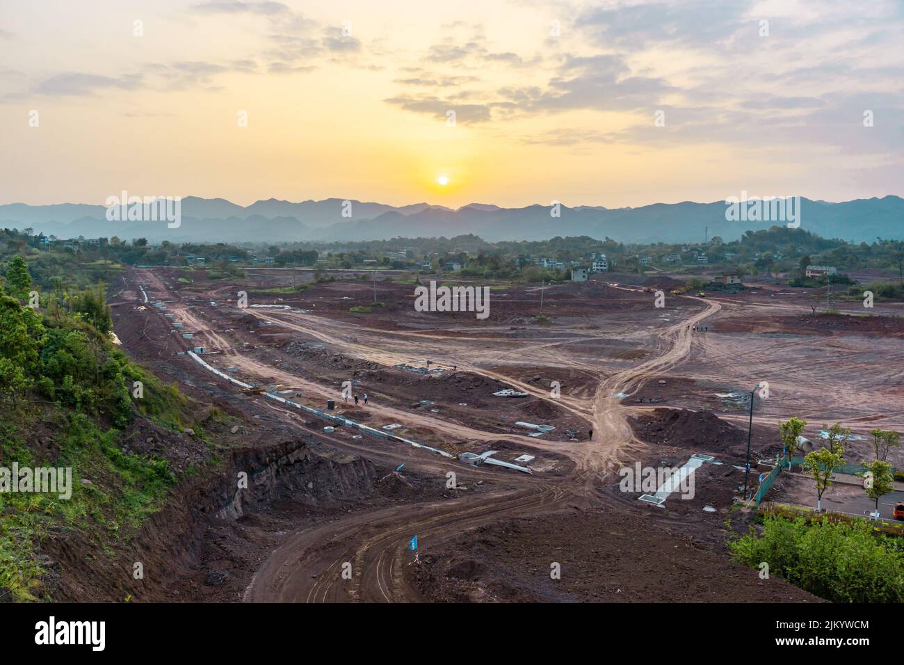 A beautiful scene of large dirt fields and green trees with houses ...