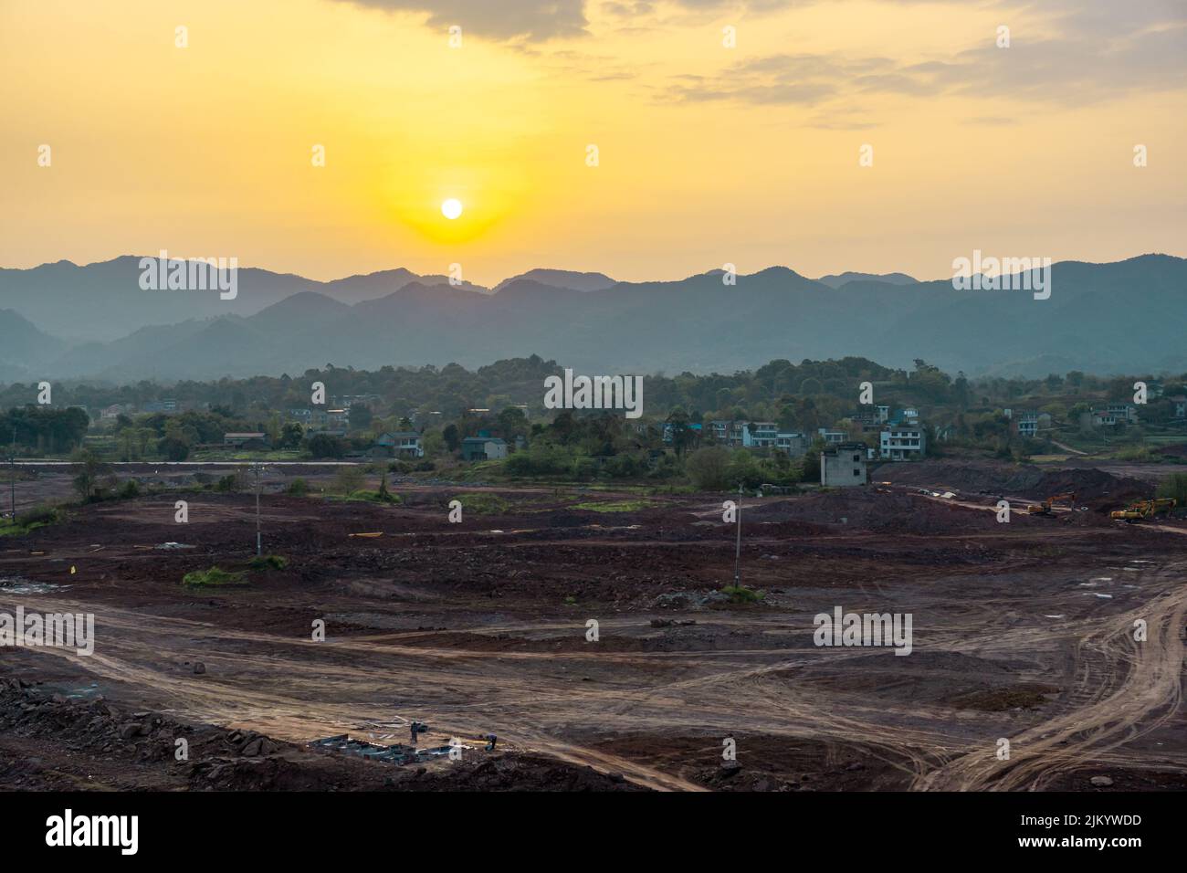 A beautiful scene of large dirt fields and green trees with houses ...