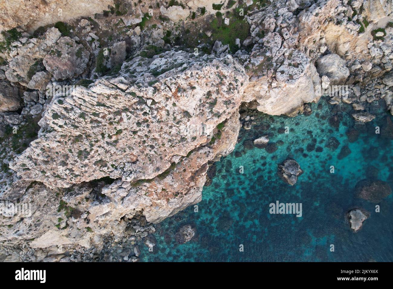 A top view of a blue ocean and a rocky cliff in daylight Stock Photo ...