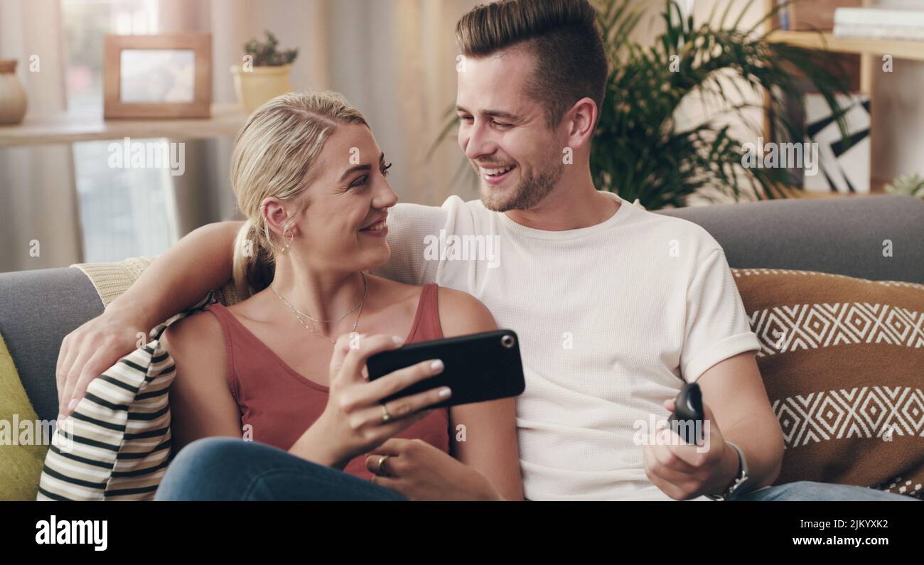 Cuddling with you warms me up inside. a young couple using a smartphone ...