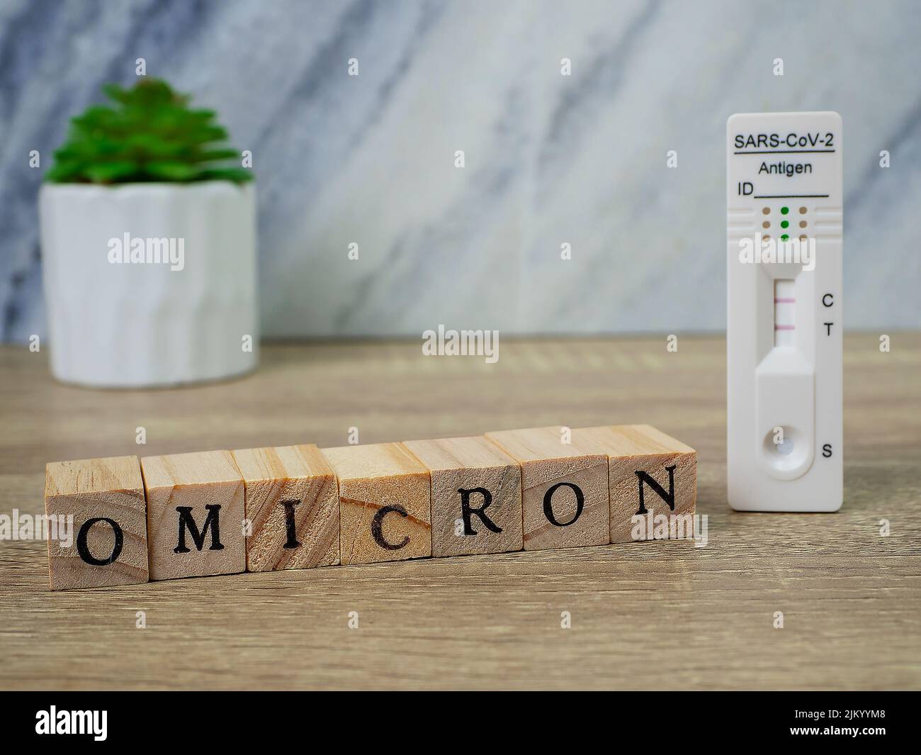 A closeup of a Covid-19 antigen test and wooden blocks with the word ...