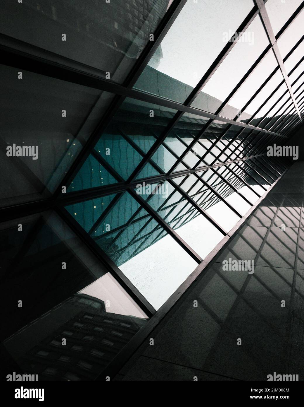 A vertical low angle shot of a modern building in a glass facade Stock ...