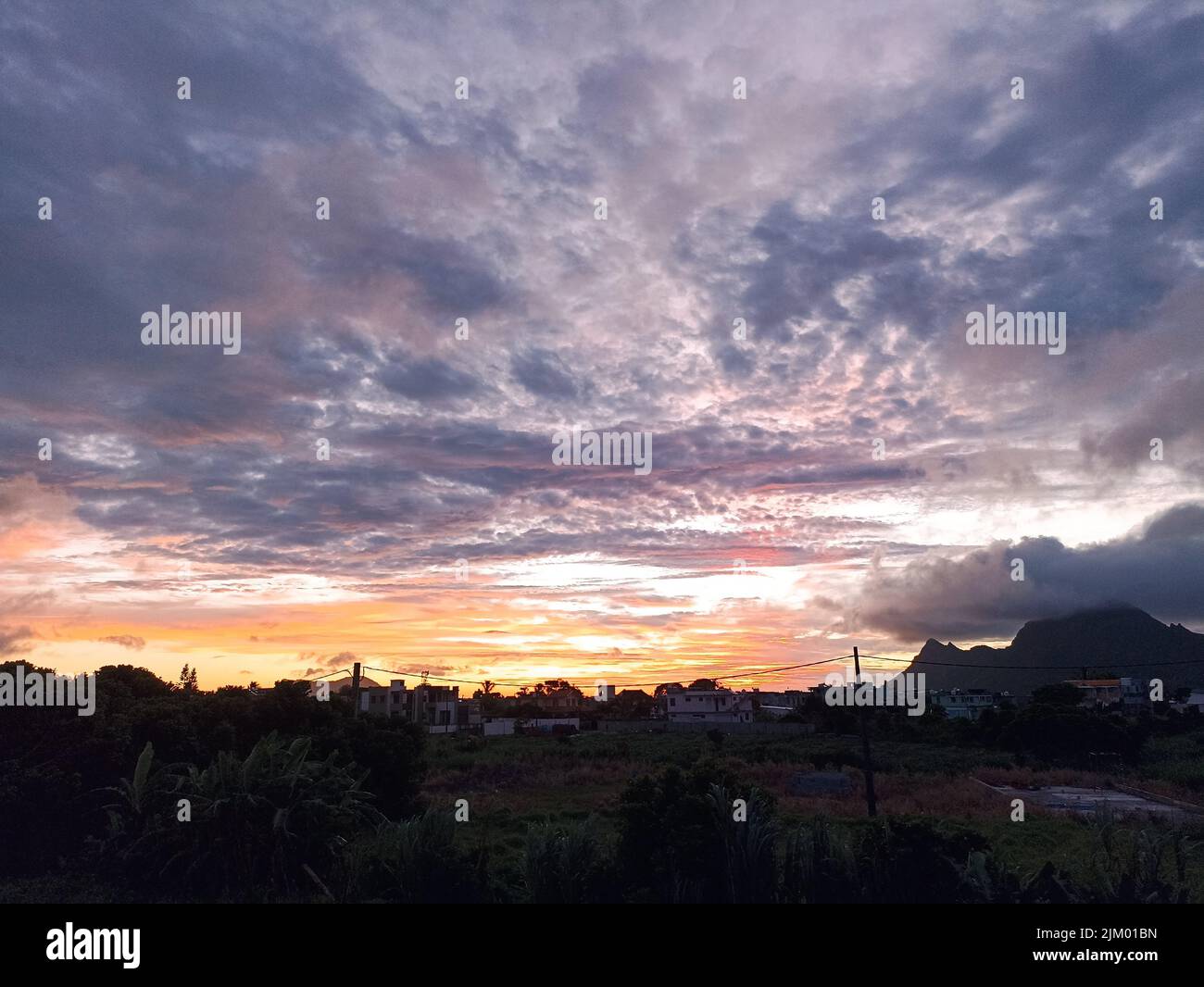 A scenic sunset above the small rural village with houses Stock Photo ...