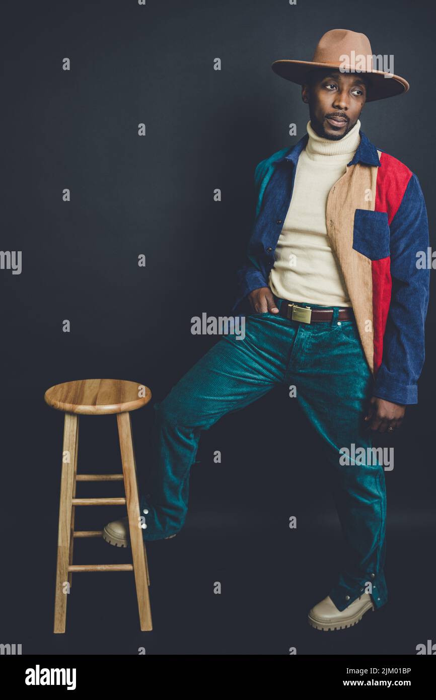 A vertical studio shot of an African American male model posing in ...