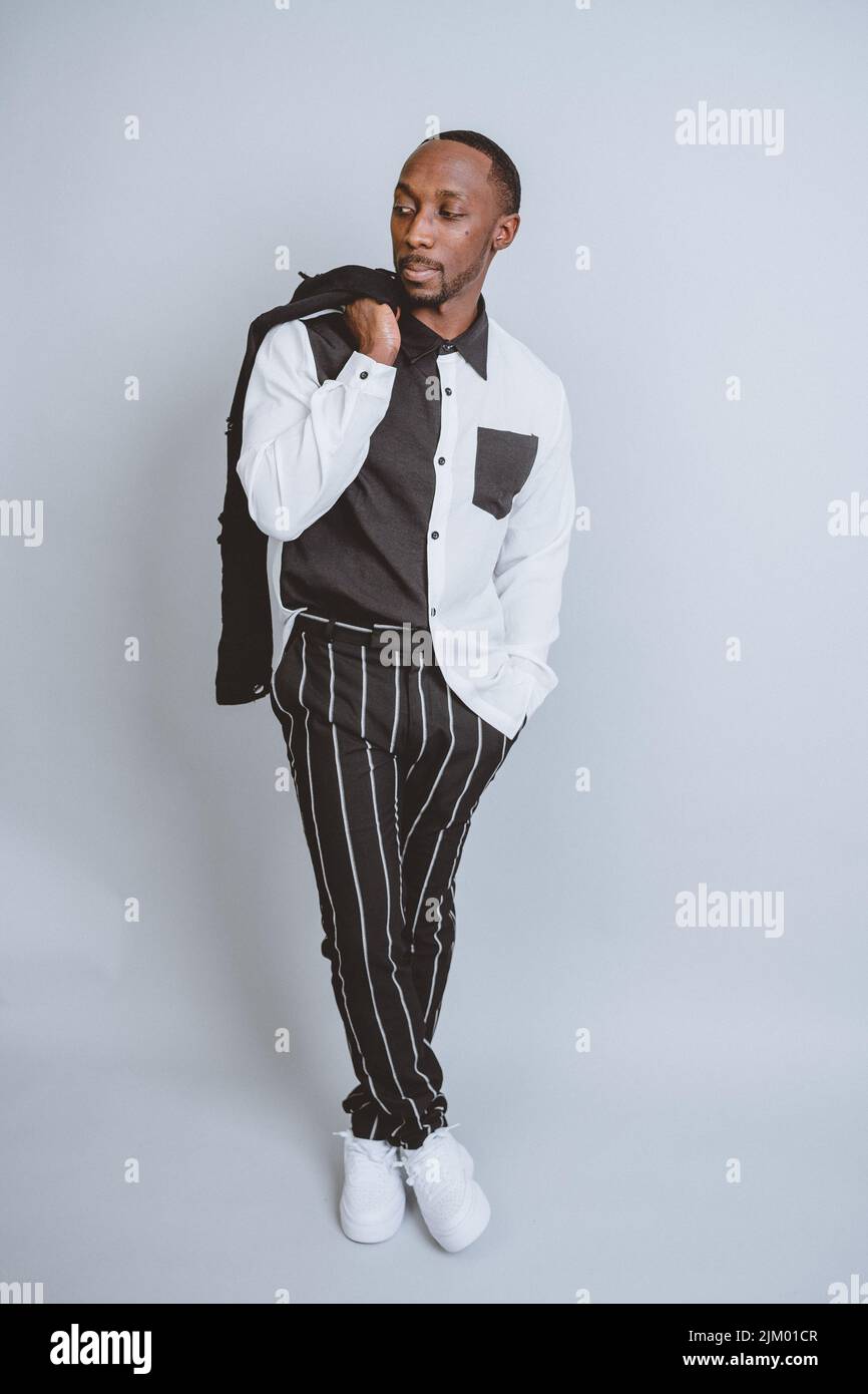 A vertical studio shot of an African American male model posing in ...