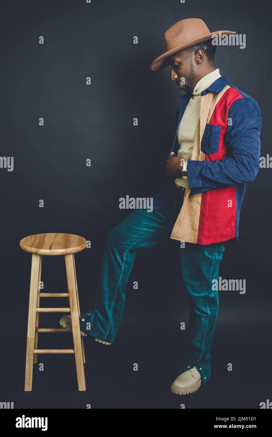 A vertical studio shot of an African American male model posing in ...