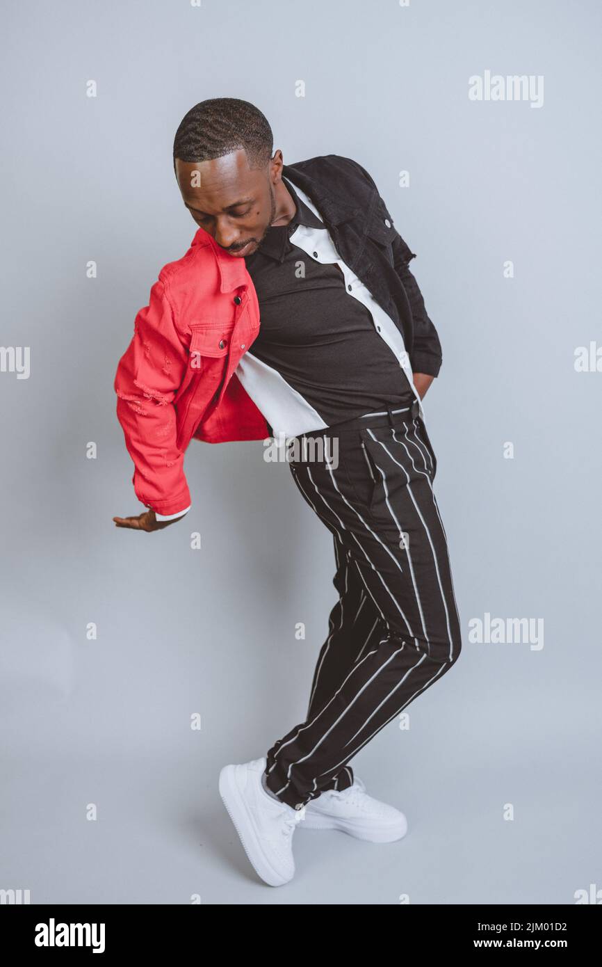 A vertical studio shot of an African American male model posing in ...