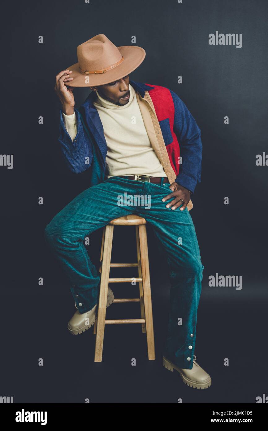A vertical studio shot of an African American male model posing in ...