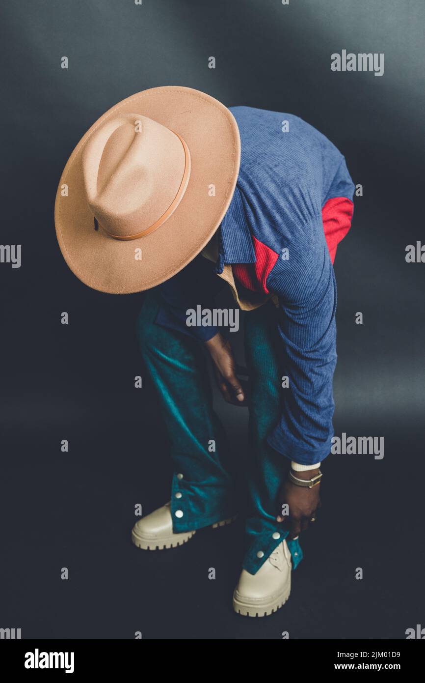 A vertical studio shot of an African American male model posing in ...
