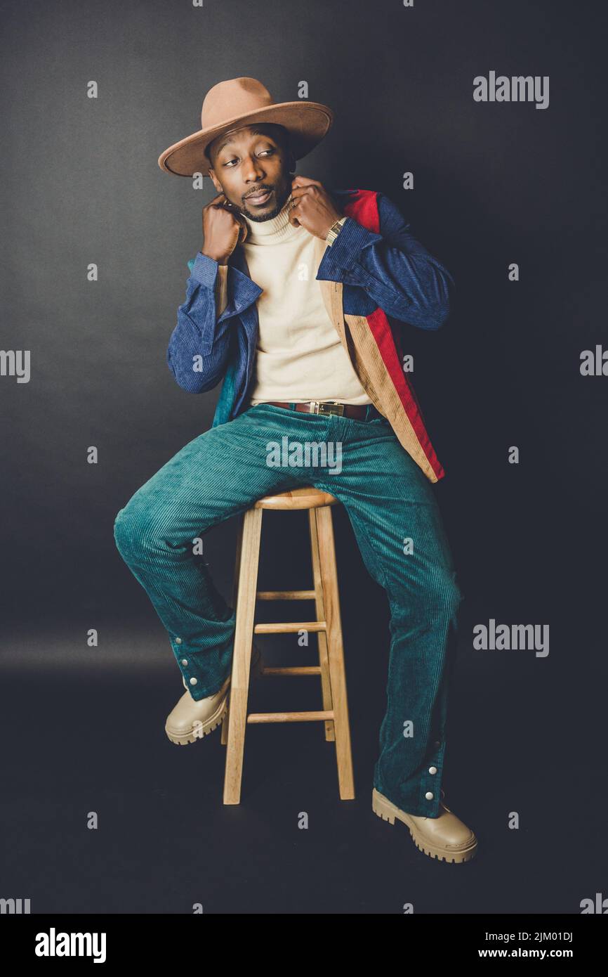 A vertical studio shot of an African American male model posing in ...