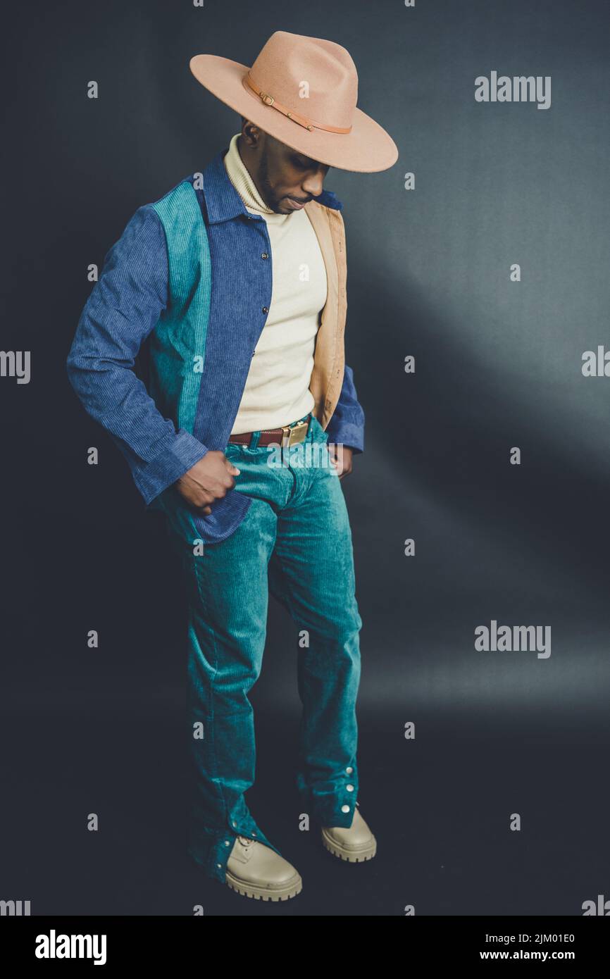 A vertical studio shot of an African American male model posing in ...