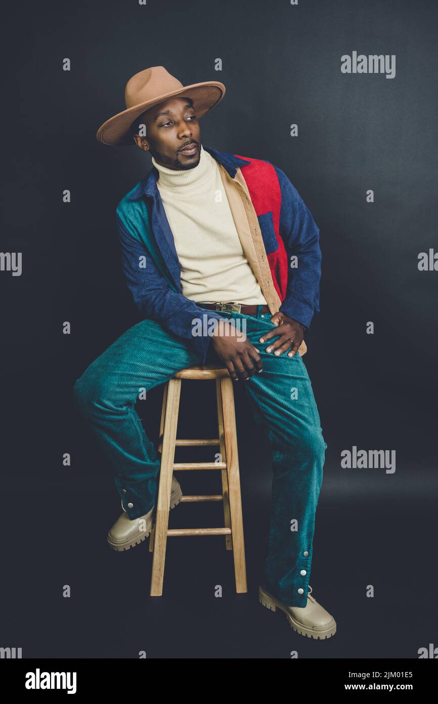 A vertical studio shot of an African American male model posing in ...