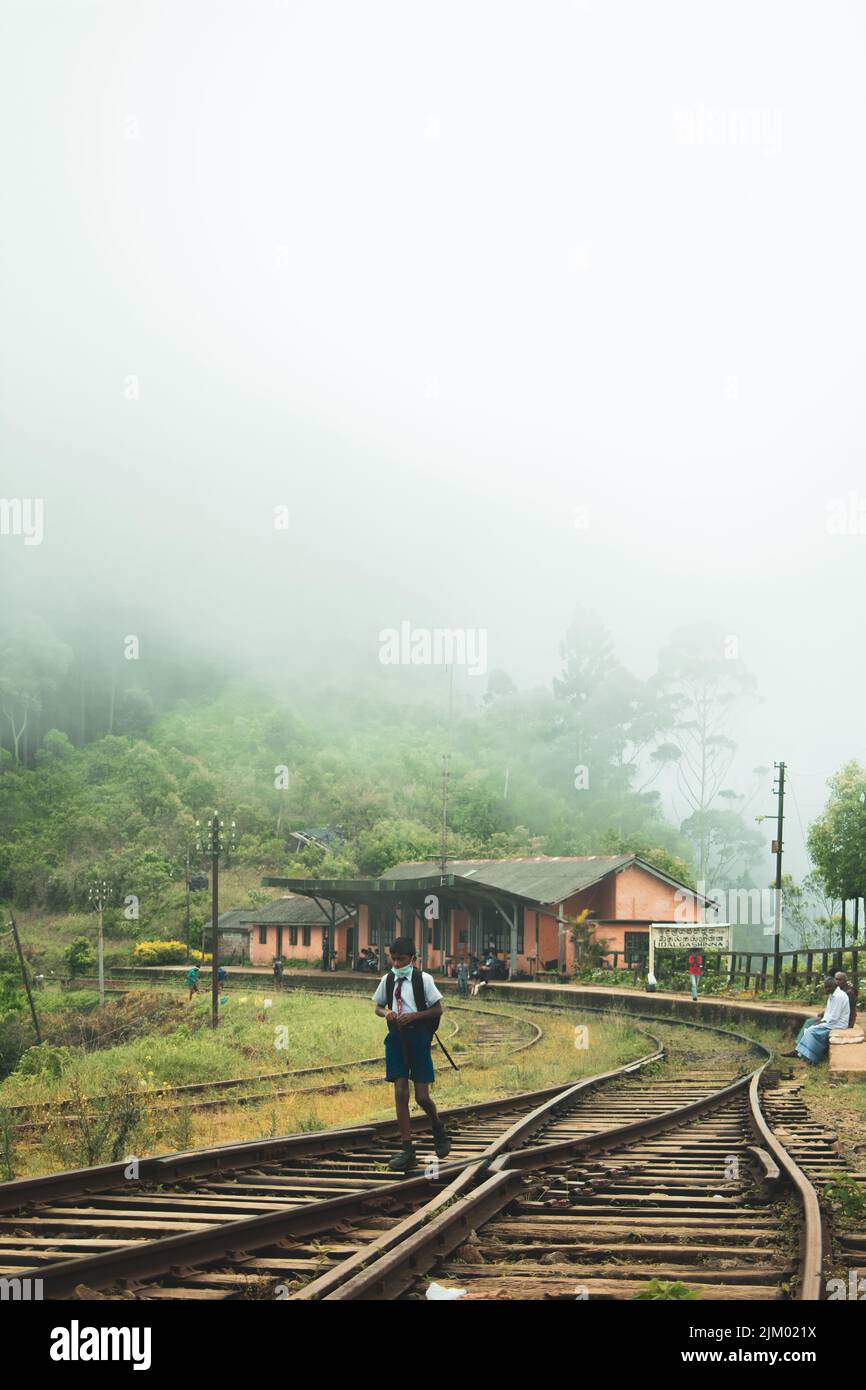 A boy returning home from school on the railroad tracks, Uva Province ...