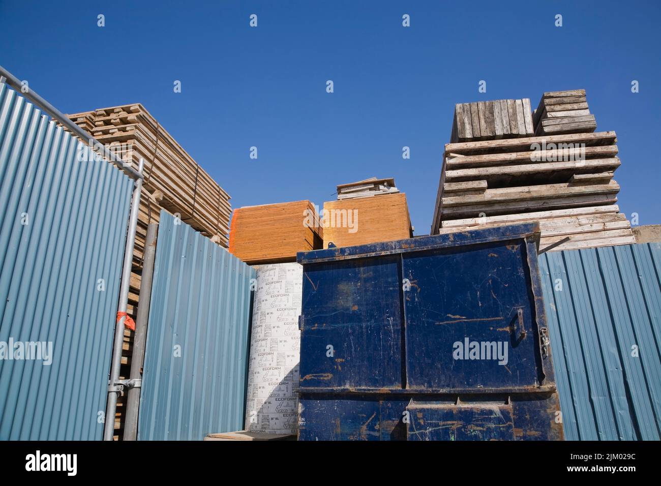 Trash container and construction materials behind metal panels security ...