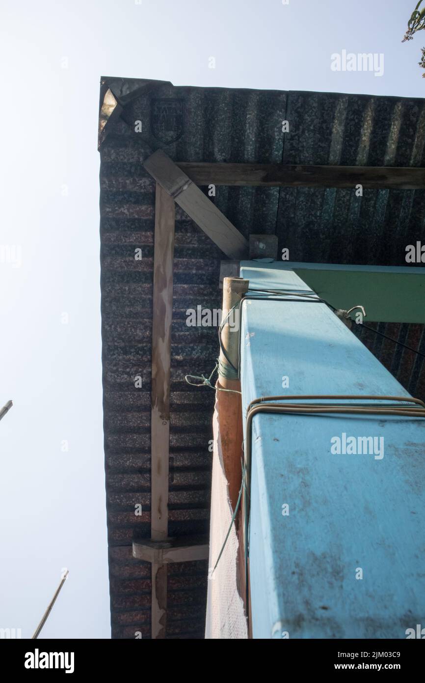 A bottom-up photo of a corner of a village house made of cement piller ...