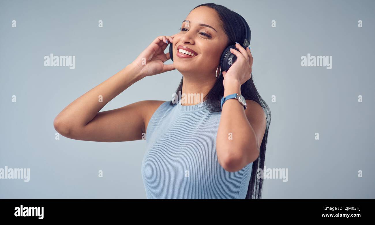 Let the music take you away. an attractive young woman listening to ...