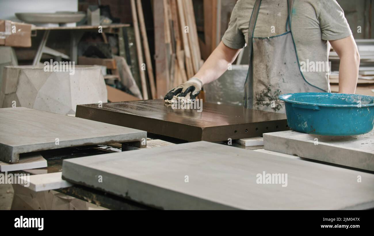 A man worker washing a concrete surface with a rag Stock Photo - Alamy