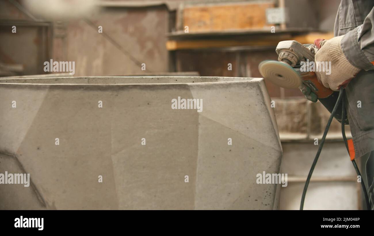 Concrete industry - polishing a big concrete figure with a grinder ...