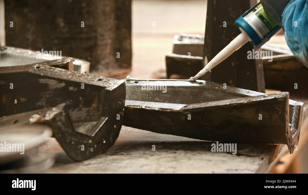 Concrete industry - young man worker applying glue on the part of whole ...
