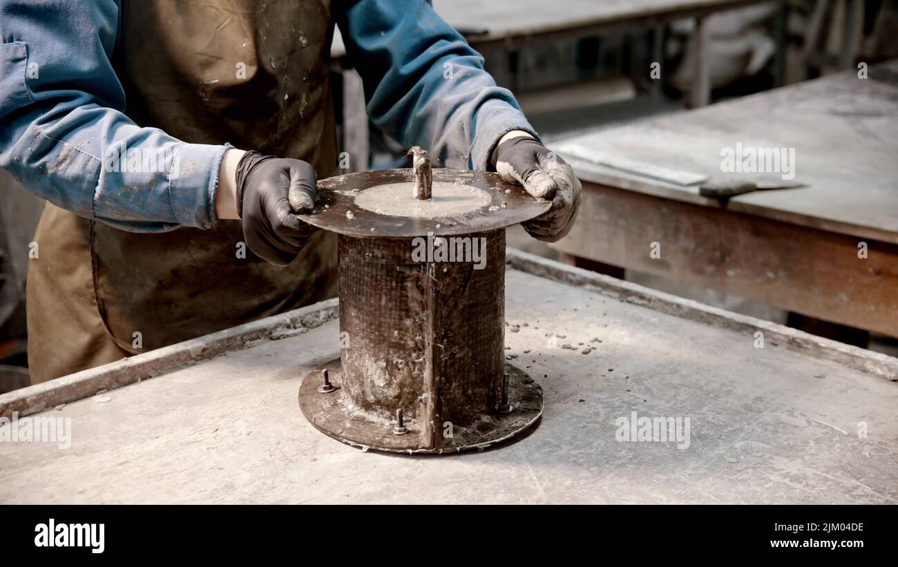 Concrete industry - man worker putting concrete in the form and ramming it with vibrations Stock ...