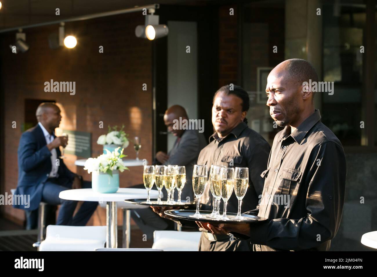 Johannesburg, South Africa - March 26, 2015: African waiter holding ...