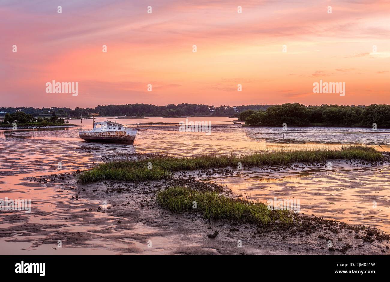 A beautiful view of an abandoned boat sits stranded at low tide in ...