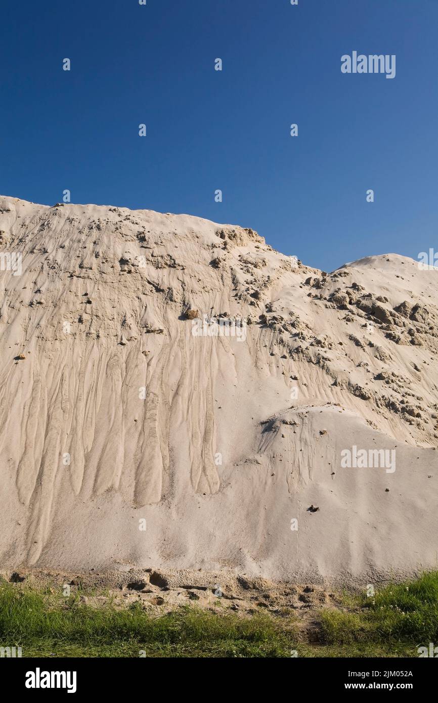 Mound of fine sand against blue sky background at construction site ...