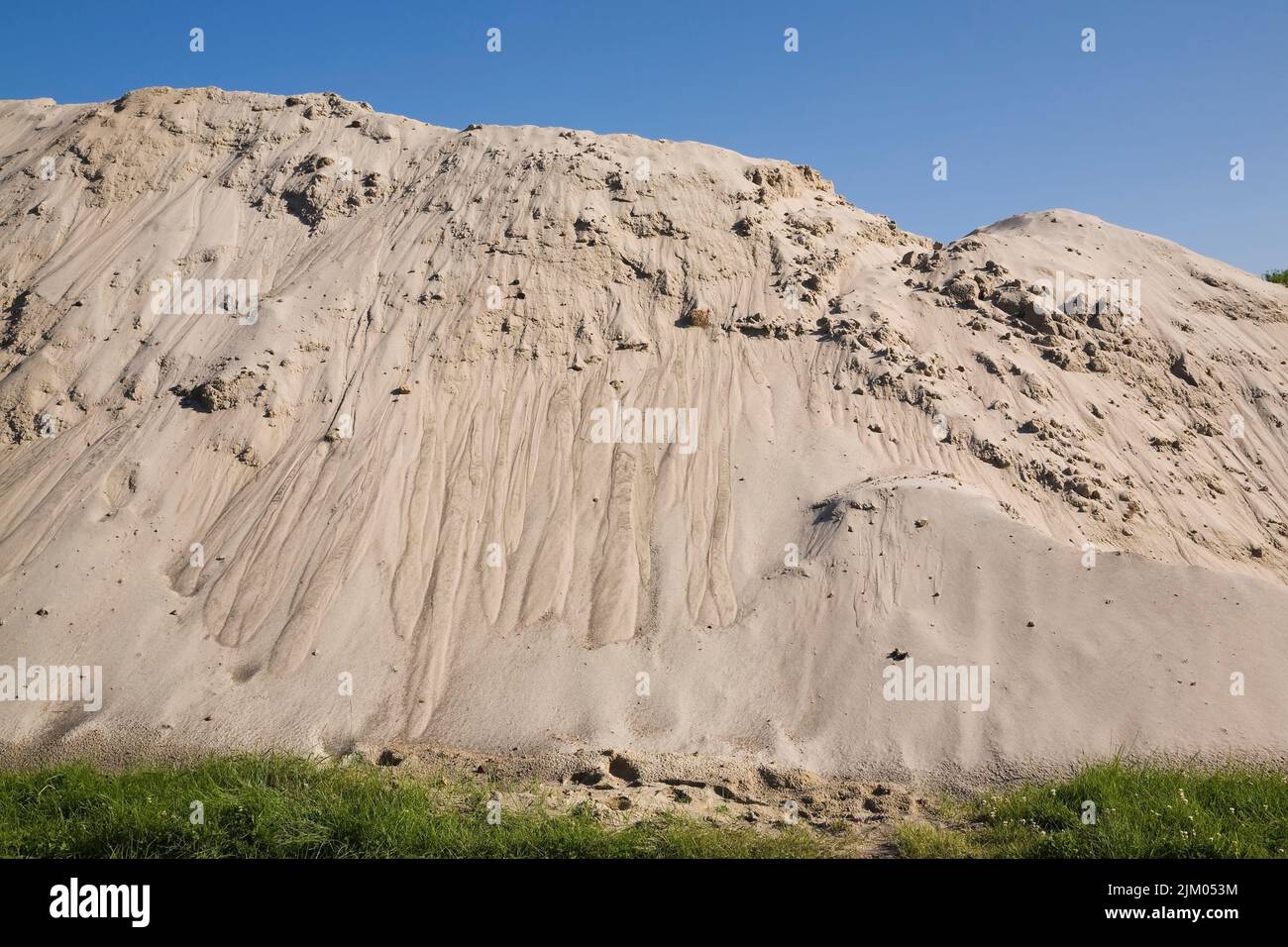 Mound of fine sand against blue sky background at construction site ...