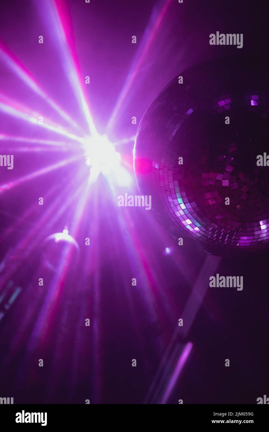 A vertical low angle shot of a disco bar and the bright purple blinding ...