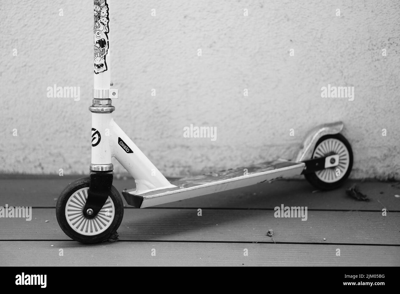 A closeup of a white Oxelo Decathlon children's scooter with graffiti ...