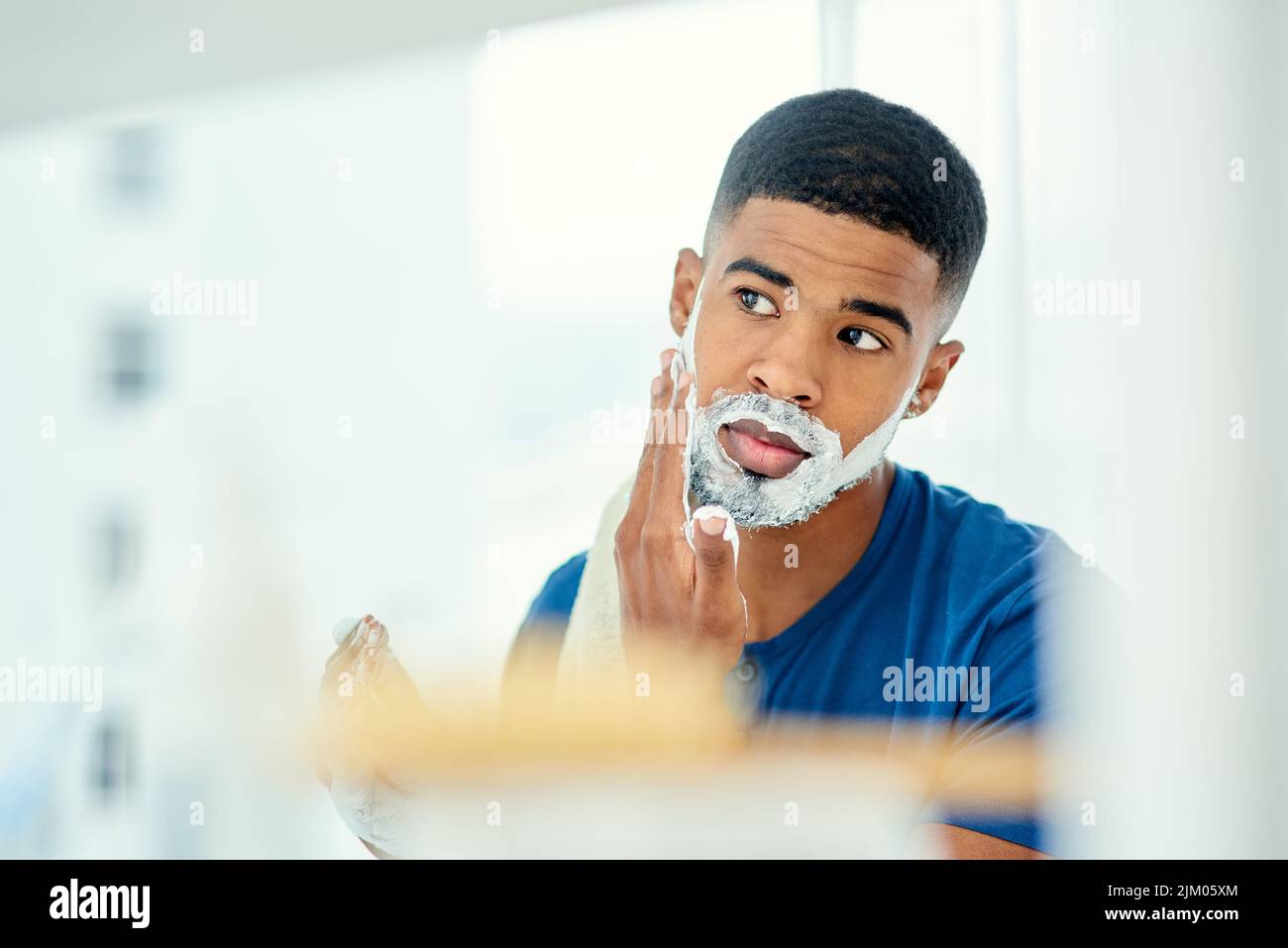This new shaving foam smells great. a young man applying shaving foam to his face Stock Photo ...