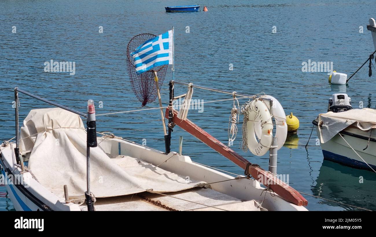 A Greek boat in the harbor on the Peloponnese, Greece, with a flag ...