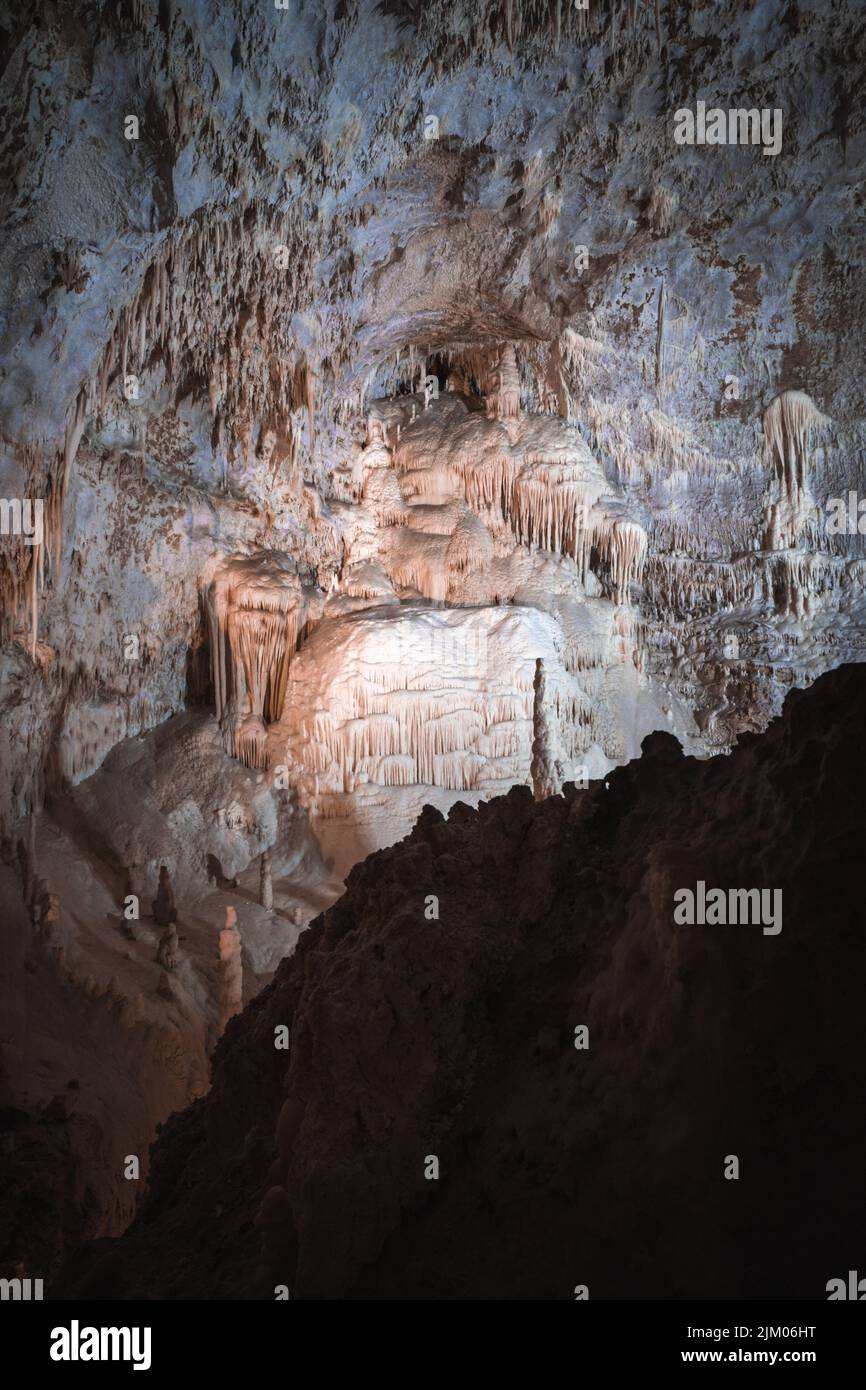 A vertical shot of The interior of a cave with rock formations and a ...