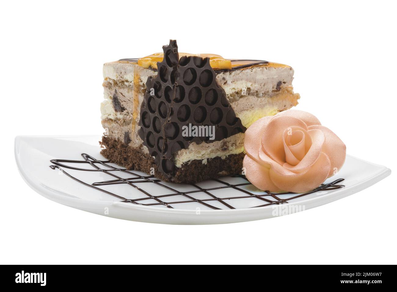 A gourmet slice of cake and a floral rose decoration isolated on a ...