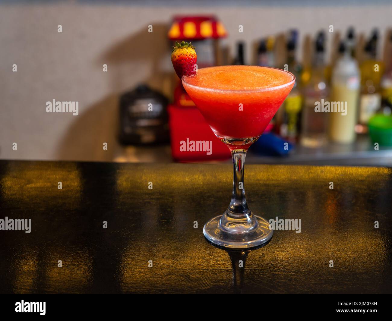 A closeup of a strawberry mocktail serve in a margarita glass on a ...