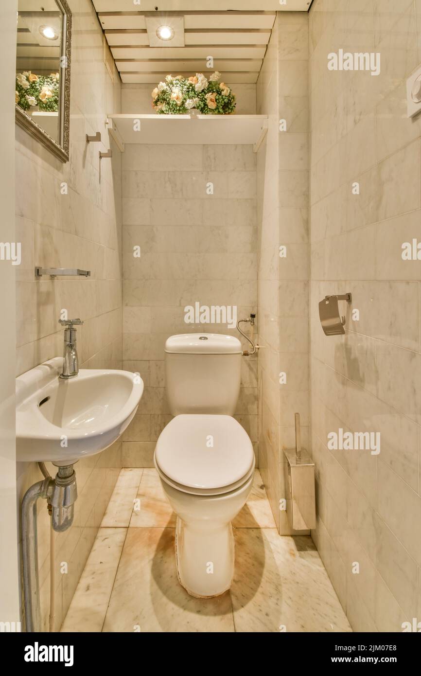 Modern Flush Toilet And Ceramic Sink Installed On White Tiled Walls