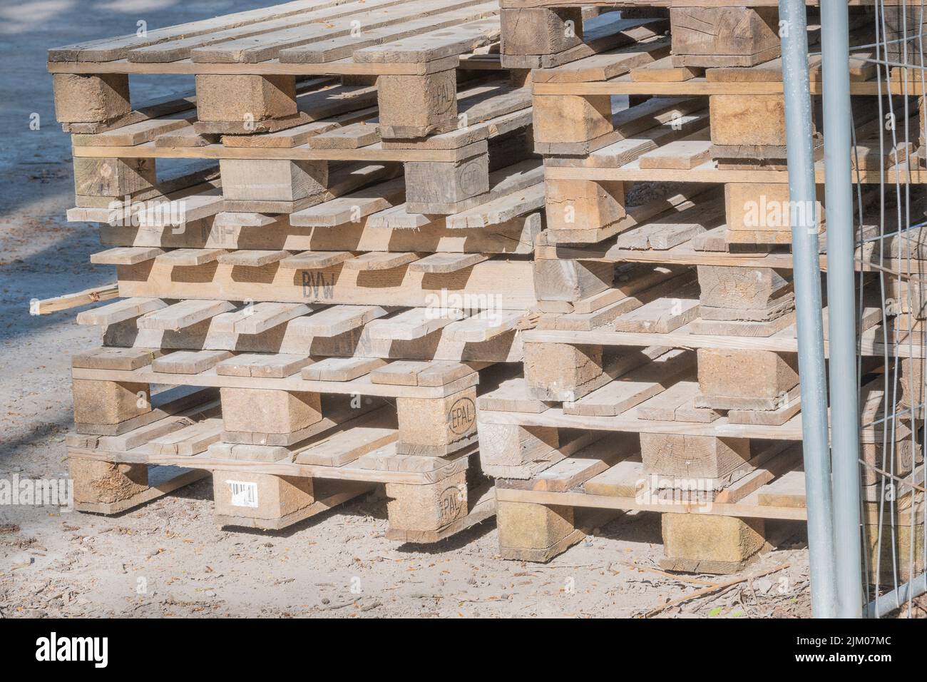 A larger quantity of stacked wooden pallets on the construction site ...