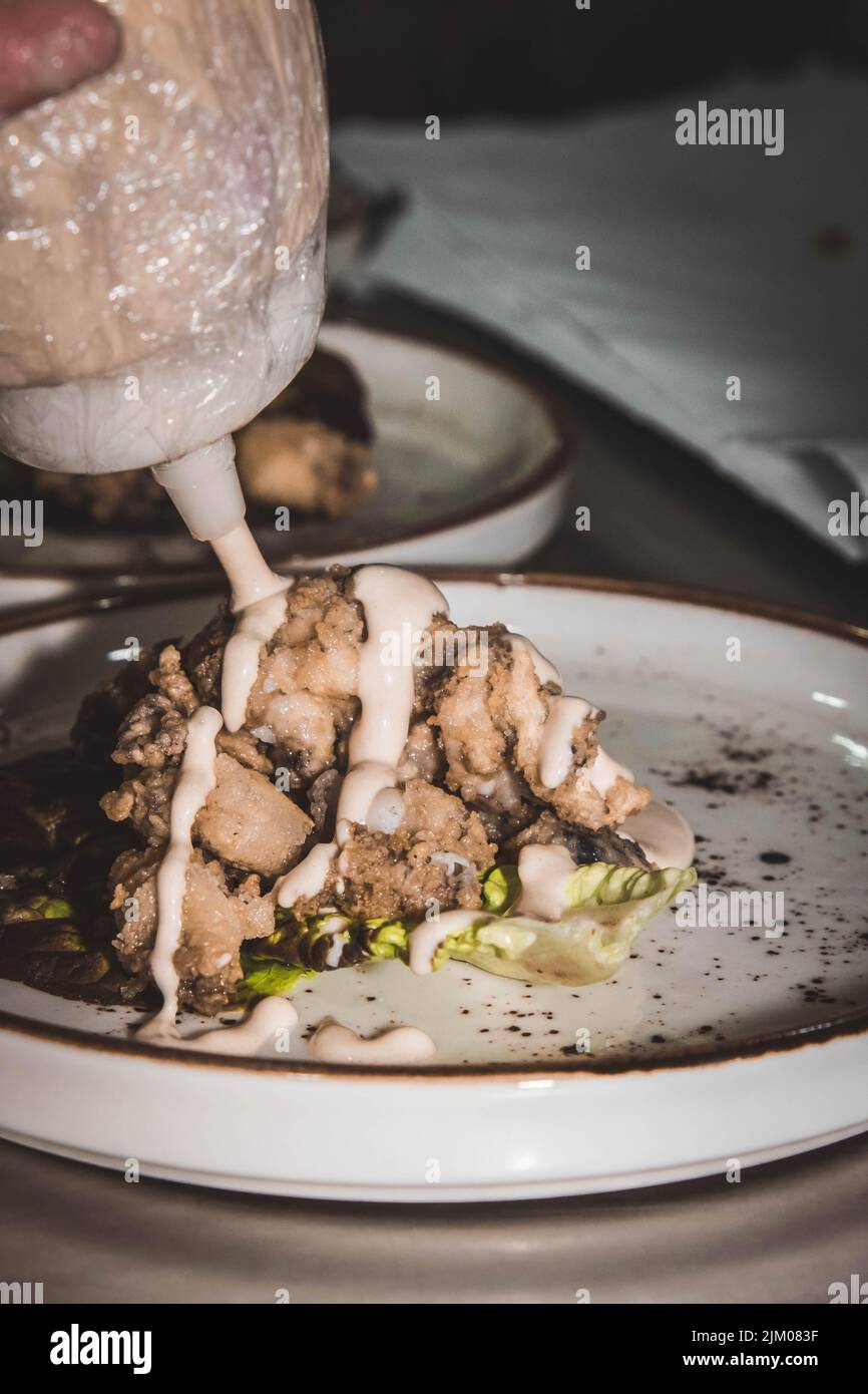 Chef finishing her plate and almost ready to serve at the table. Only ...