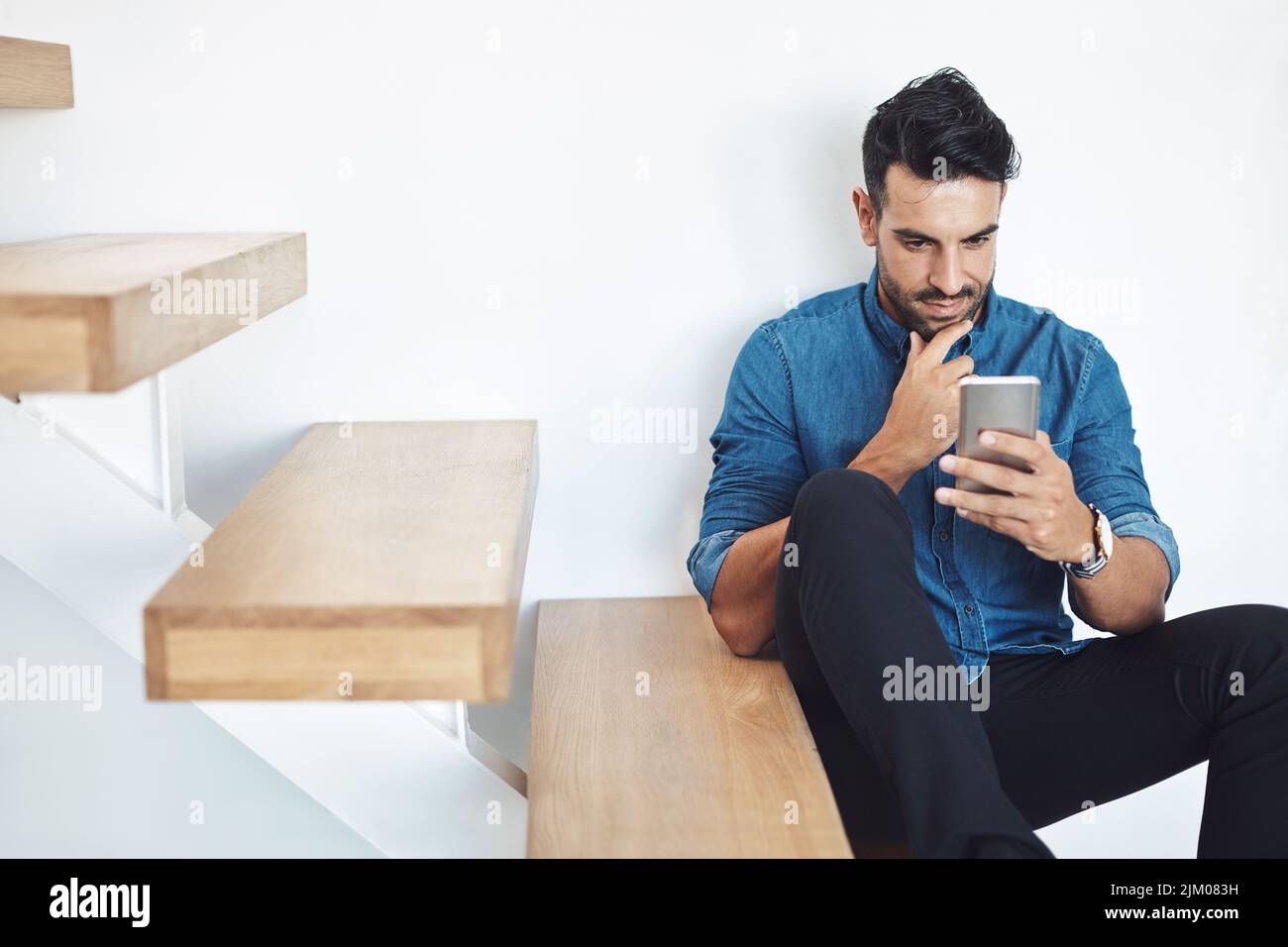 Male texting on a phone, browsing social media online while sitting on ...