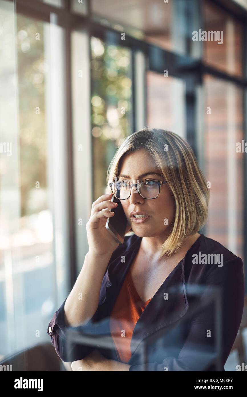Young business woman on the phone making a call in a modern office ...
