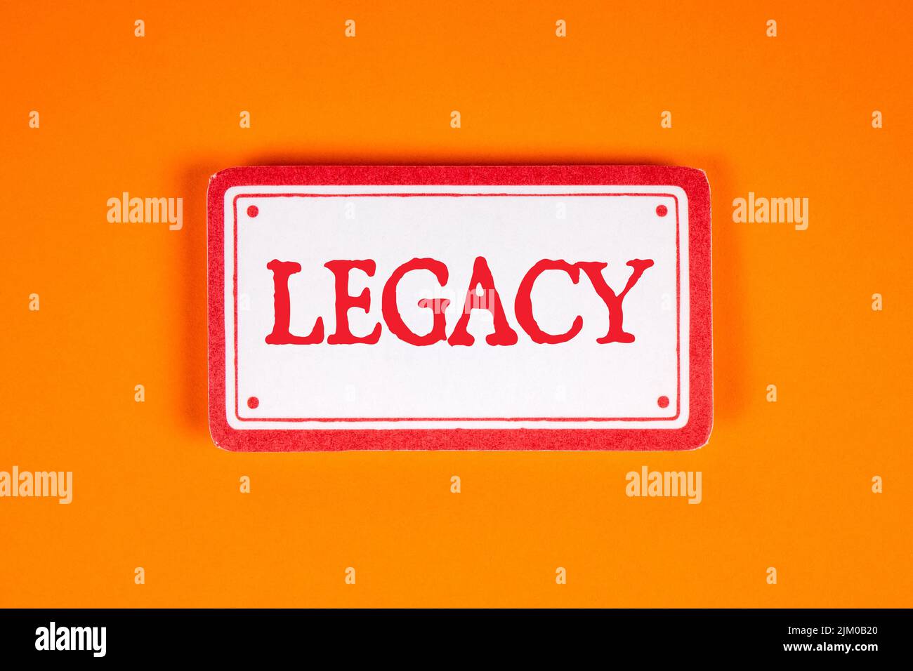 LEGACY. Word on a white piece of paper. Orange background Stock Photo ...