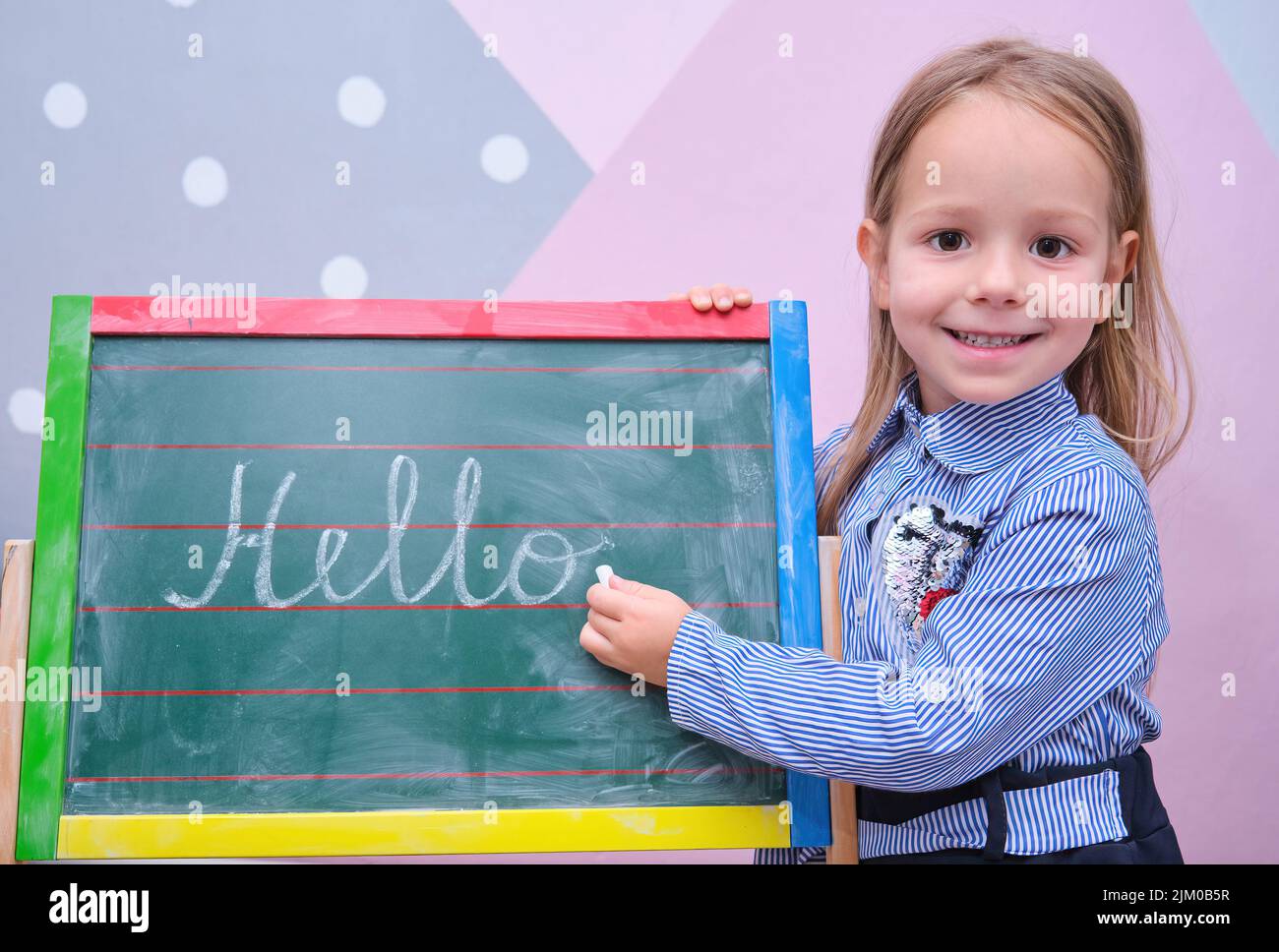 Cute happy little girl stand blackboard Homeschooling writing chalk ...