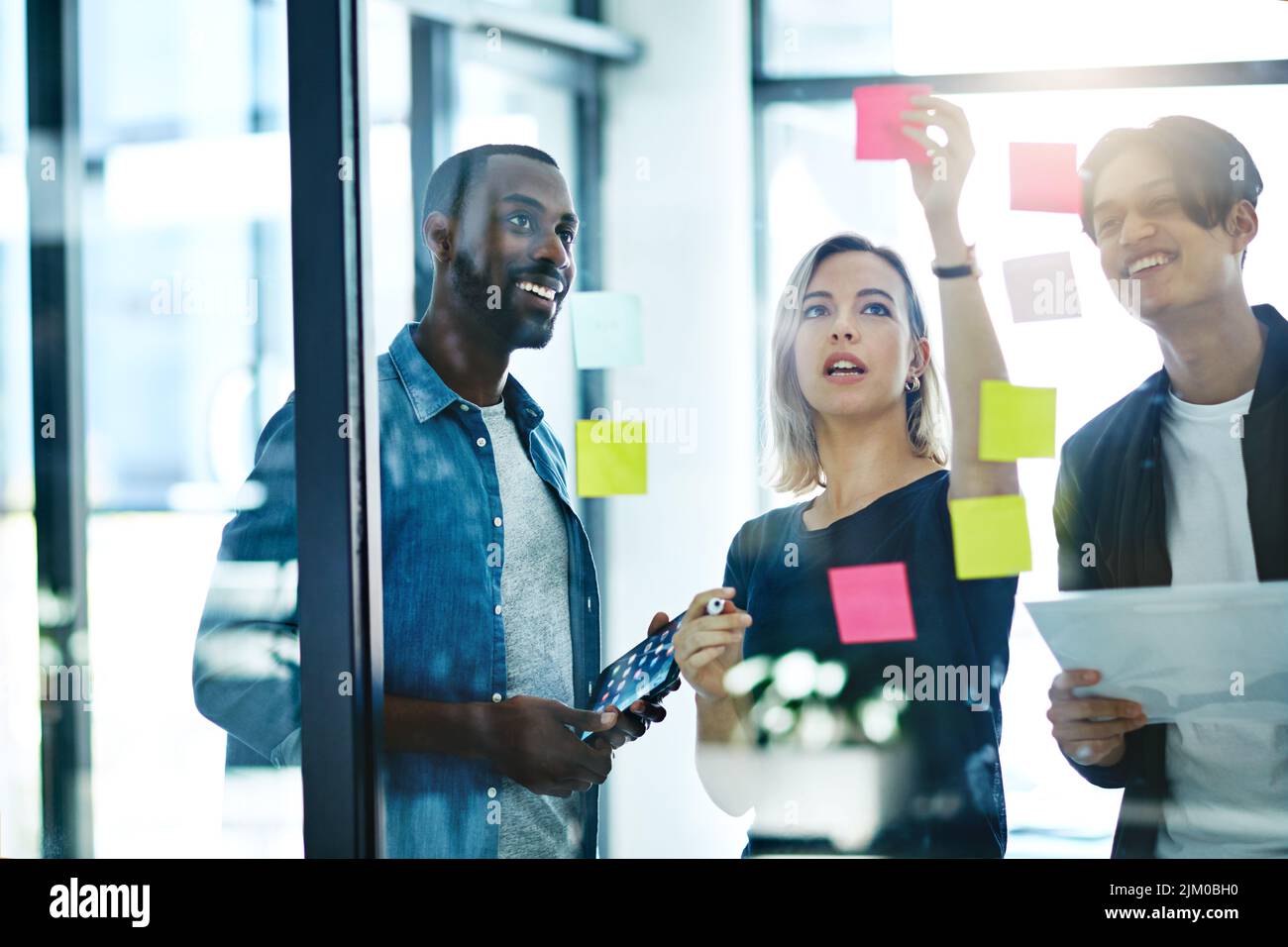 Teamwork, planning and reading sticky notes while brainstorming ...