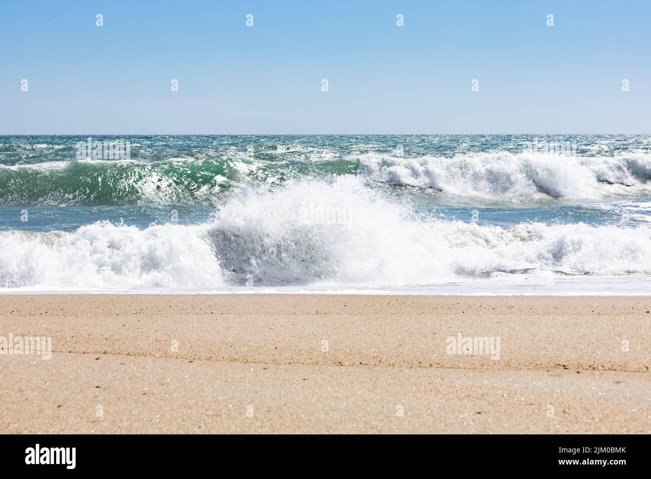 A beautiful landscape view of ebb and flow on a sandy beach with blue ...