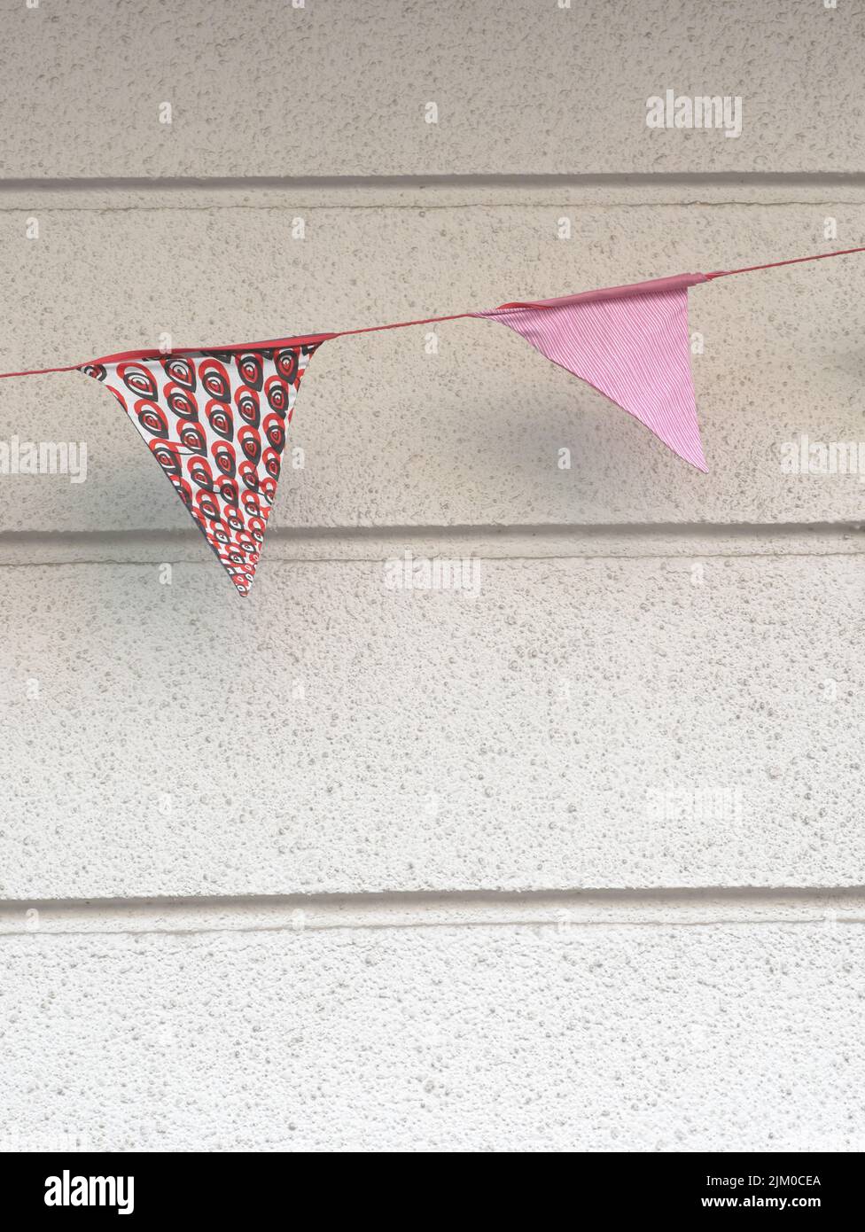 Pink bunting with two triangles in front of a house Stock Photo - Alamy