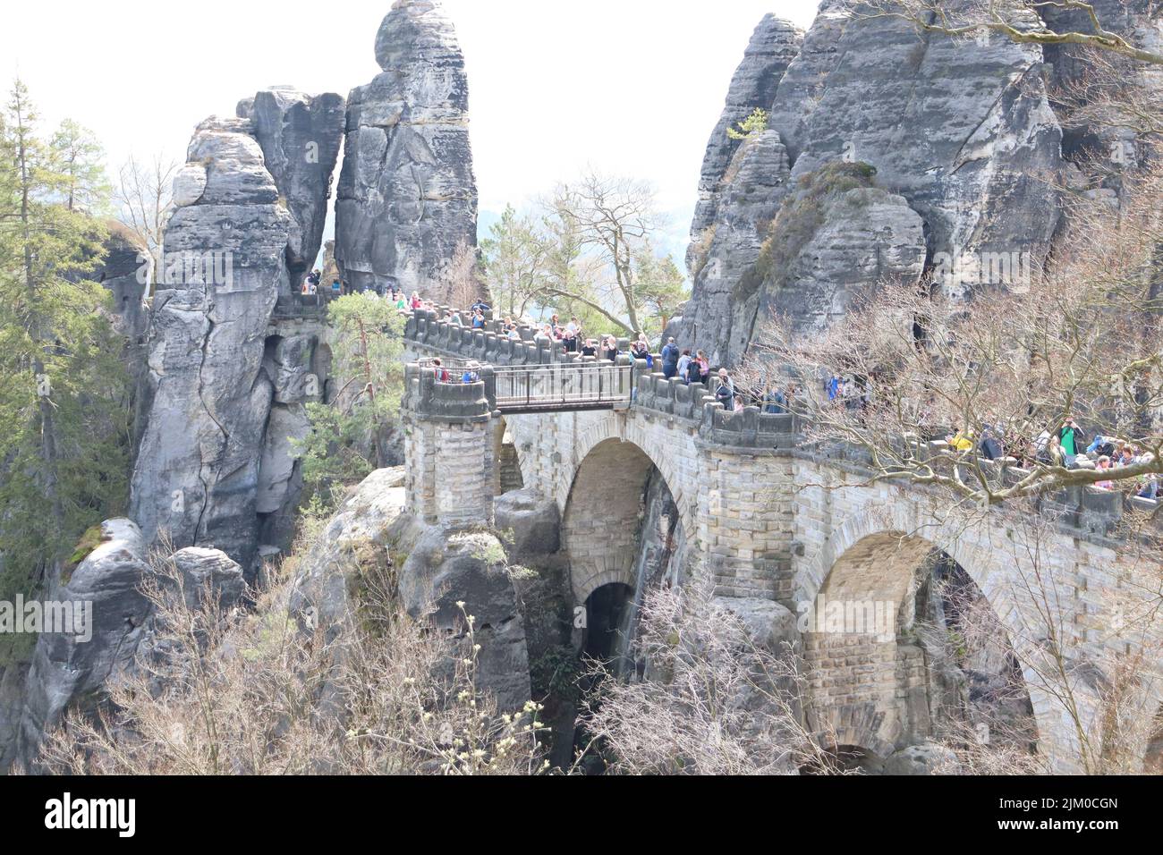 A scenic view of Bashtai rock formation and a bridge covered with trees ...